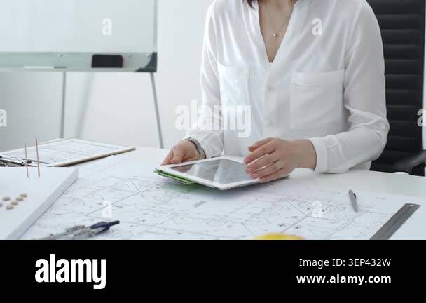 Woman professional working on building plans and design project using ...