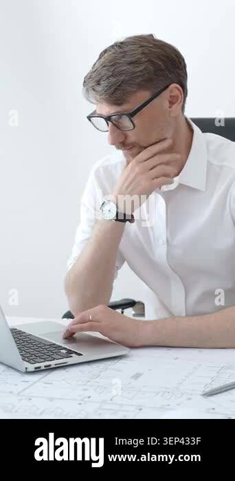 Professional male architect or engineer concentrating on blueprints and ...