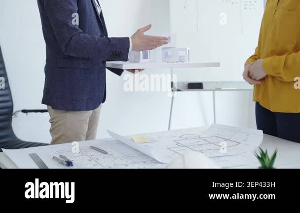 Architect presenting a contemporary building model to a collaborator ...