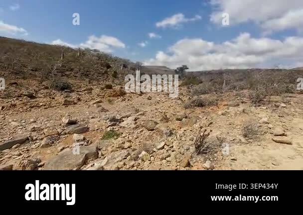 Rocky dry hillside under a blue sky with scattered clouds from a ...