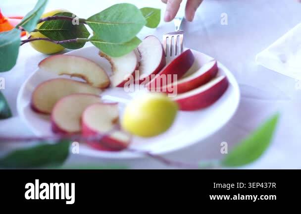 Selective focus shot of a person using a silver fork to pick up a slice ...