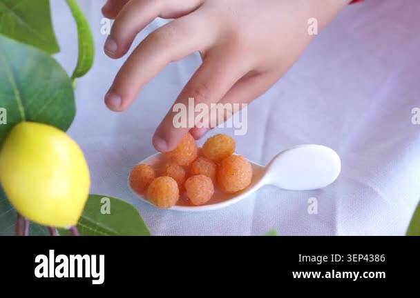 Close up shot of a child's hand gently taking a fresh, ripe yellow ...