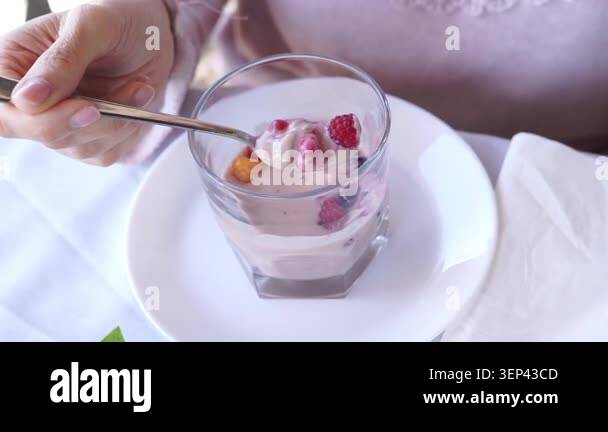 Close up of a woman's hand using a spoon to eat a delicious and healthy ...