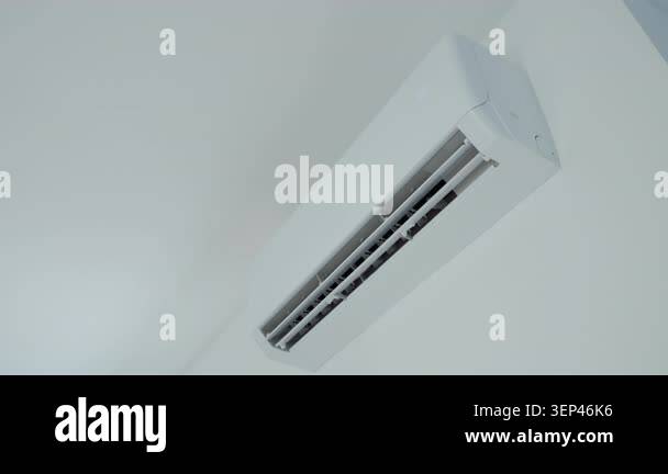Wall mounted air conditioner with open vents on a white wall. Concept ...