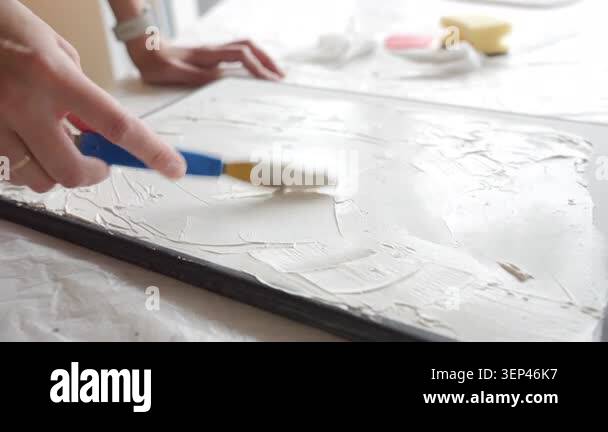 Artist create a textured picture. Hands spreading white decorative ...