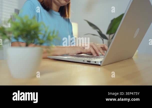 Close-up image of a woman's hand using a laptop and typing on a ...