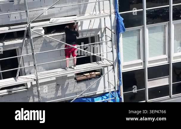 Construction worker installing windows on a building facade with ...
