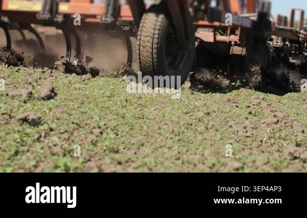 Close-up of seeding machinery working through cultivated farmland ...