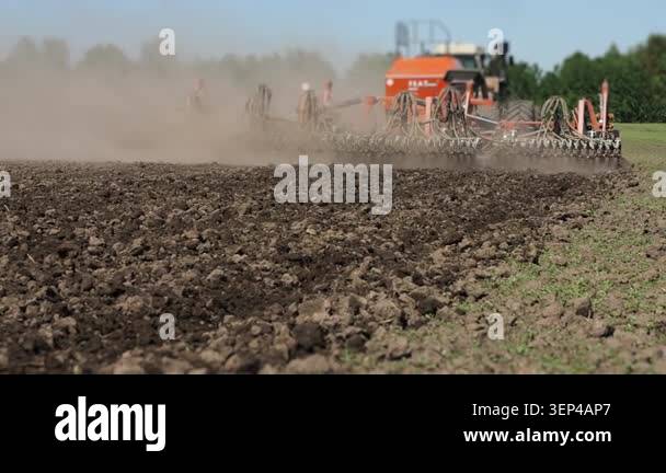 Agricultural seeder operating on farmland during sowing season. Modern ...