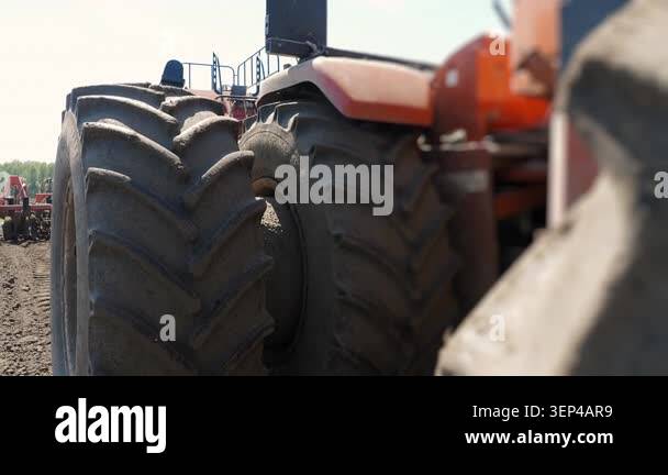 Low angle view of large agricultural tractor wheels on cultivated ...