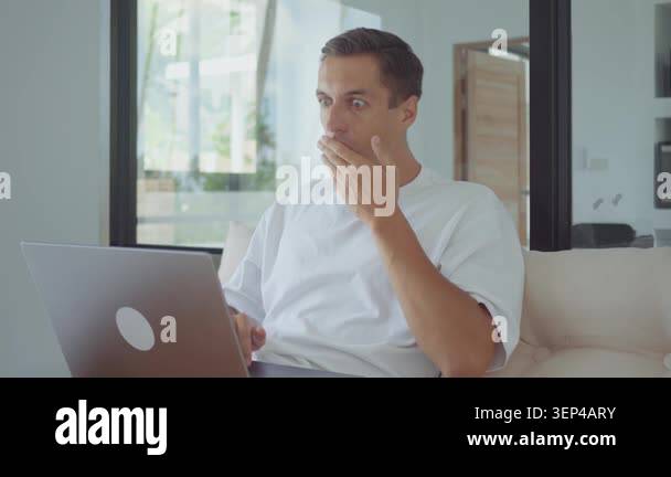 surprise man looking at laptop with shocked expression after unexpected ...