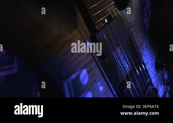 Artistic close-up of a guitar illuminated by glowing, dancing musical ...