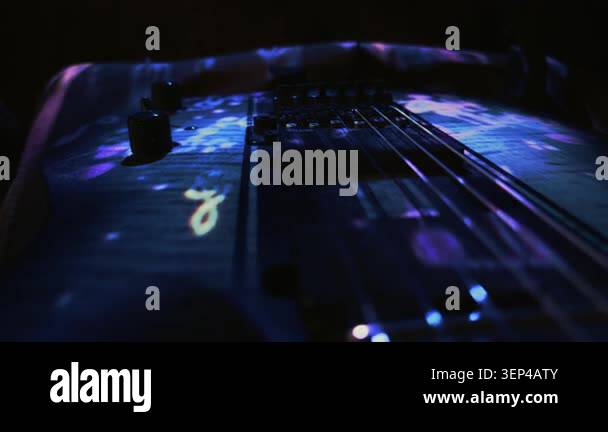 Artistic close-up of a guitar illuminated by glowing, dancing musical ...