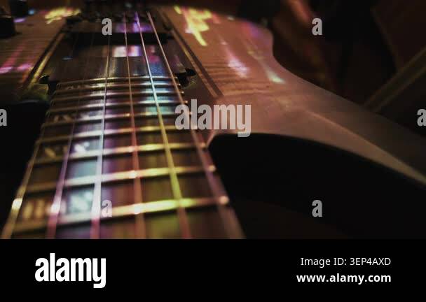 Artistic close-up of a guitar illuminated by glowing, dancing musical ...