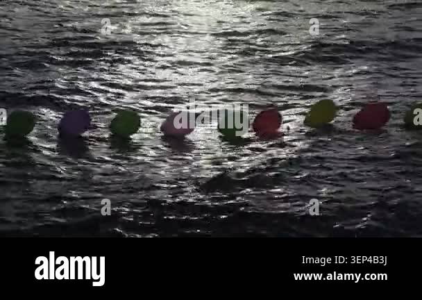 Colorful balloons are lined up along the seaside, creating a cheerful ...