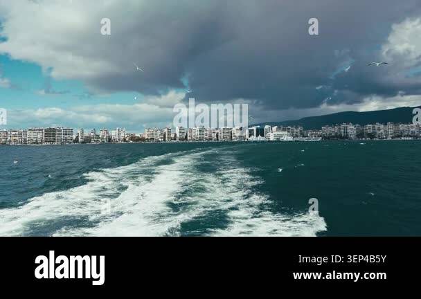 Seagulls fly and follow a moving ferry over the sea in Izmir, Turkiye ...
