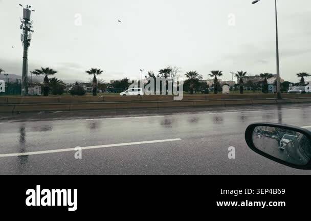 Traffic is seen through a car windshield on a rainy day, with raindrops ...