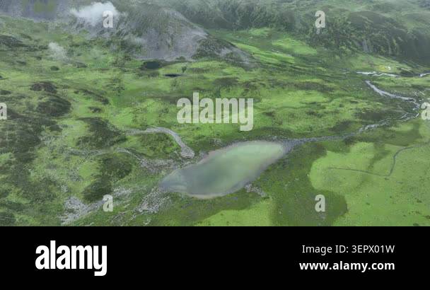 Aerial drone footage flying over a lush green mountainous landscape ...