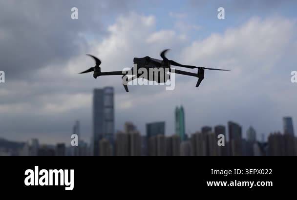 A drone flies in the sky with a city skyline in the background. Aerial ...