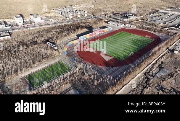 Aerial view of a sports complex with a football field and running track ...