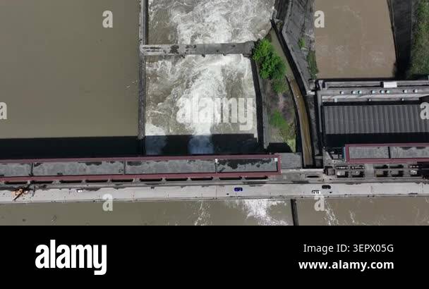 Aerial view of a dam with water flowing rapidly through the spillway ...