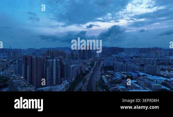 Aerial view of a sprawling city skyline at dusk with traffic flowing on ...