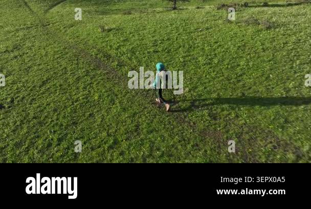 Aerial view of a person with a backpack walking on a grassy path with ...
