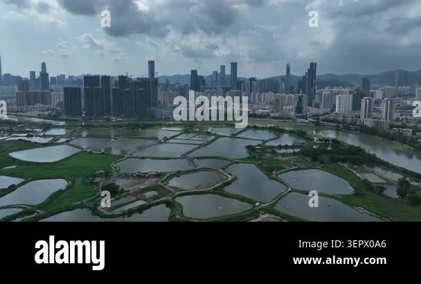 Aerial drone footage flying over aquaculture ponds towards a sprawling ...