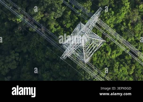 Aerial view of a tall electricity pylon with power lines stretching ...