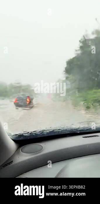 Driver's point of view driving on a flooded road during severe weather ...