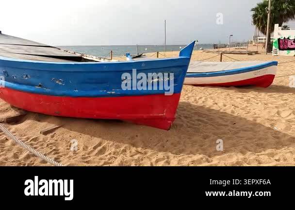 Traditional wooden fishing boats resting on a sunny sandy beach in ...