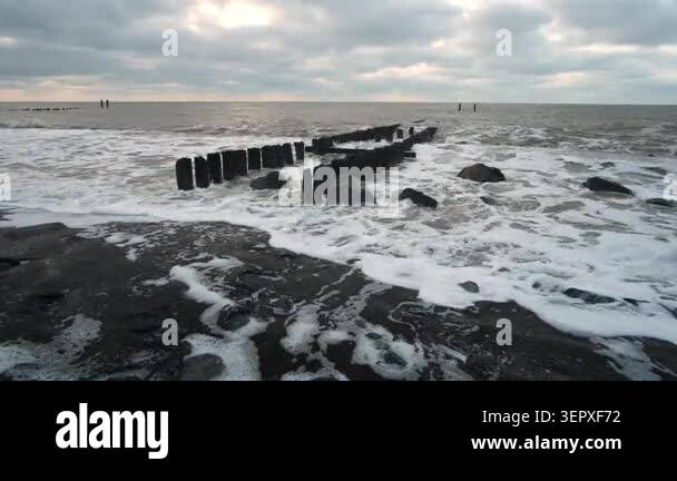 Foamy Sea Waves Crashing Against Weathered Wooden Groynes In a Stormy ...