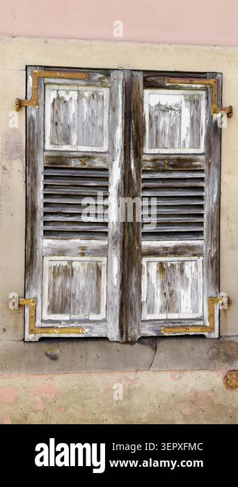 Vertical video shows weathered, wooden, louvered window shutters on a ...