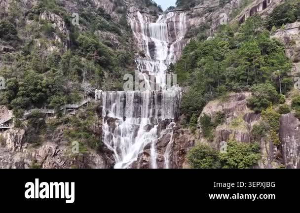 Lush green mountains with multiple cascading waterfalls flowing over ...