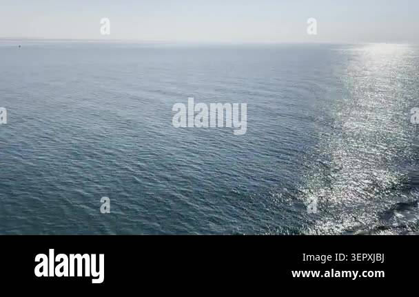 Tracking shot shows sunlight reflecting off water as ferry crosses the ...