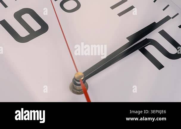 Macro shot of wall clock second hand moving and crossing the midnight ...