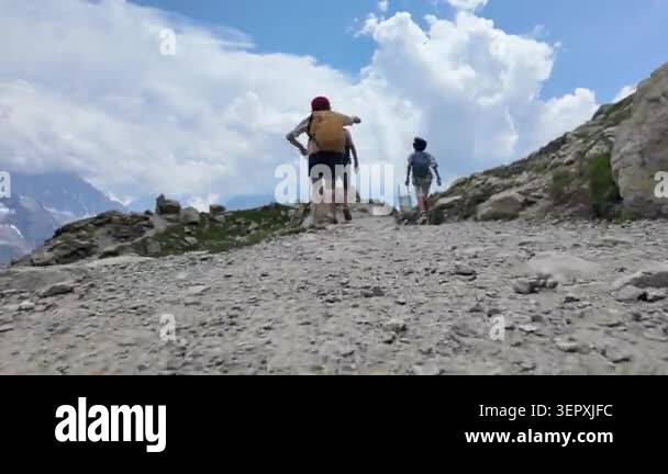 mother and two kids hiking on a rocky mountain trail with dramatic ...