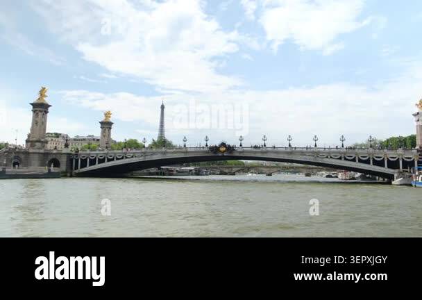 Wide shot of the Alexandre III bridge in Paris with the Eiffel Tower in ...