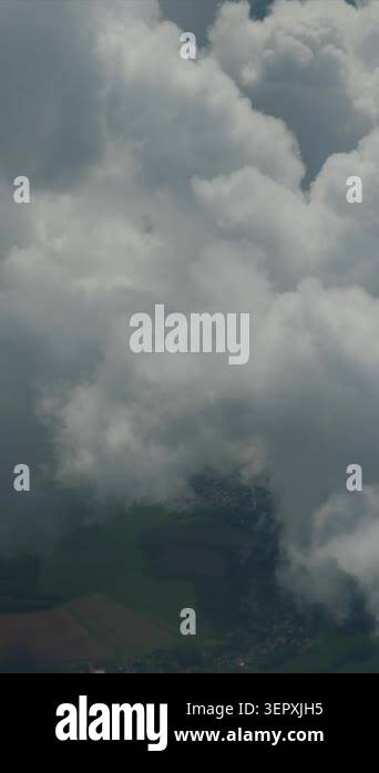 Vertical video showing aerial view through clouds of agricultural ...