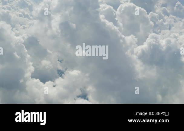 Aerial view of fluffy white clouds drifting across a bright blue sky ...