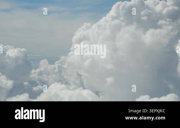 Close-up view of fluffy white cumulus clouds against a blue sky, with ...