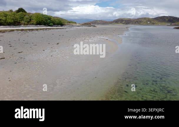 Low-altitude drone shot tracking sideways over the crystal-clear ...