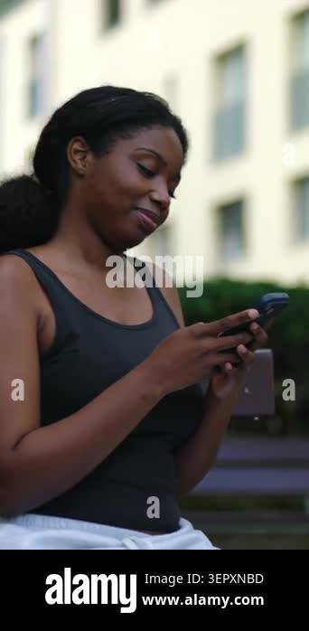 Young African American Woman interacting with mobile phone in peaceful ...