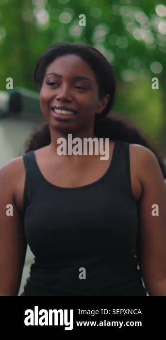 Young African American Woman moving through a neighborhood with assured ...