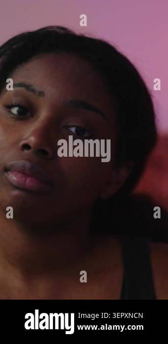 Young African American woman looks forward with a relaxed and ...