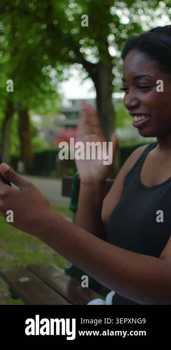 Young African American Woman greeting someone during mobile video ...