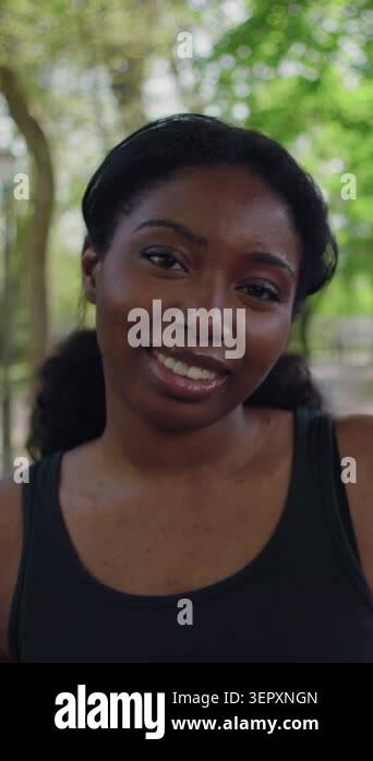 Young African American woman smiles while spending time outdoors in a ...