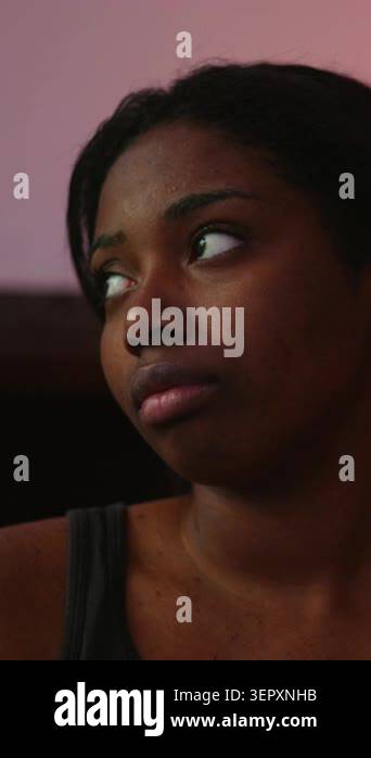Young African American woman looks directly toward viewer with calm ...
