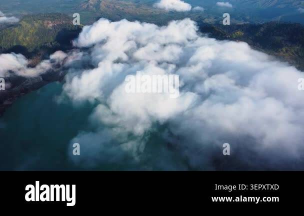 Majestic aerial view flying over the clouds covering the kawah ijen ...