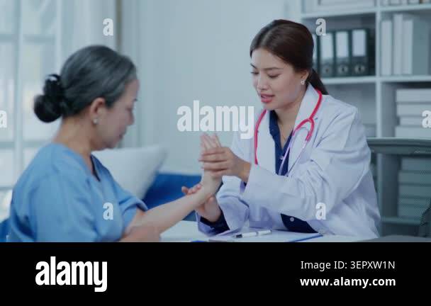 Doctor examining elderly woman's wrist in clinic Stock Video Footage ...